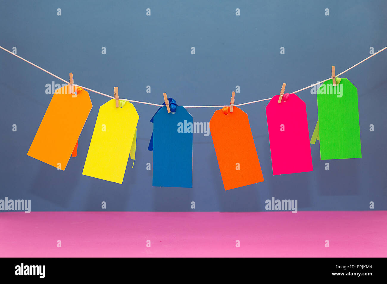 Six Colorful Paperboard Tags Hanging on a String Stock Photo - Alamy