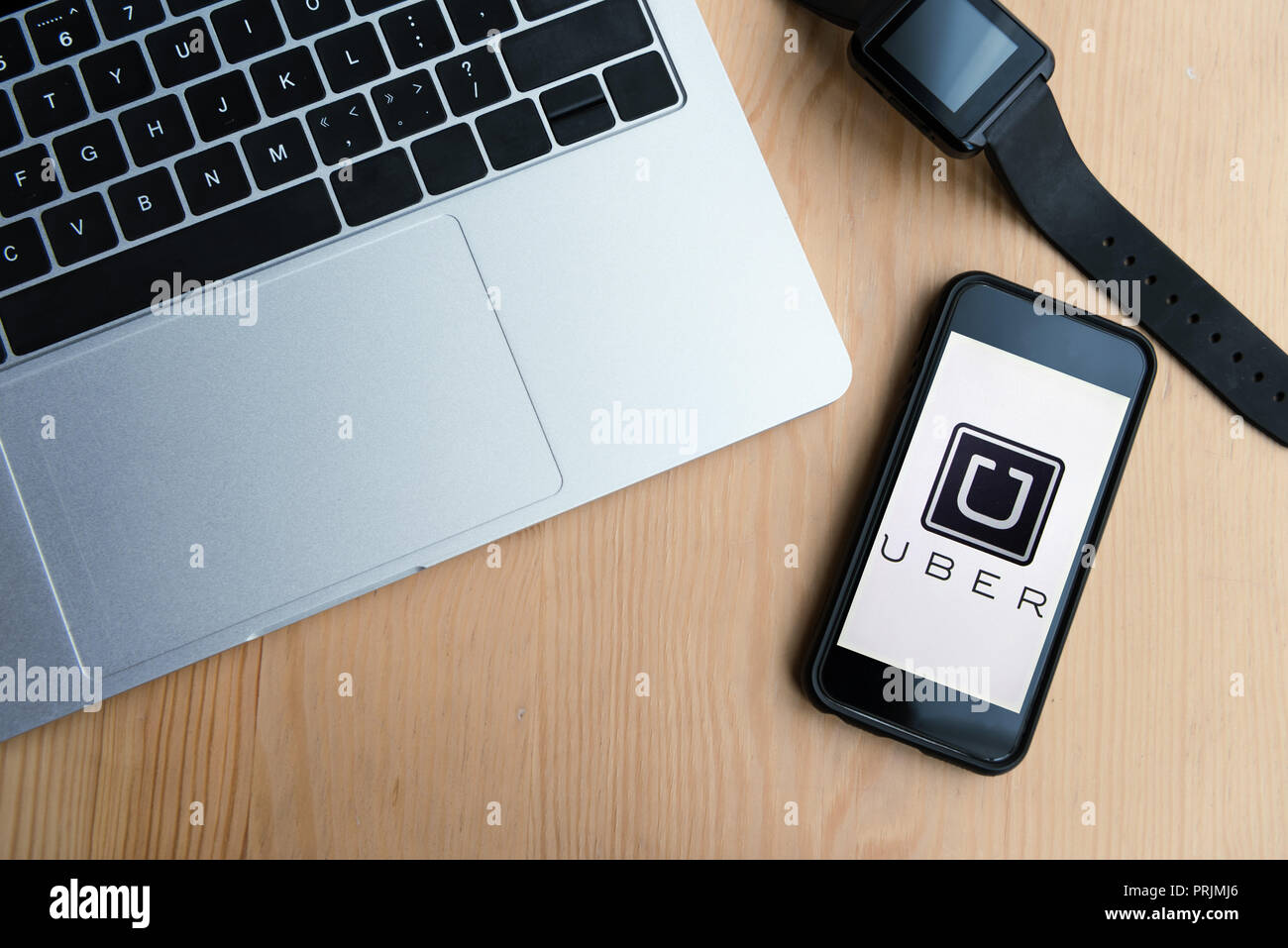 top view of laptop, smartwatch and smartphone with uber app on screen ...