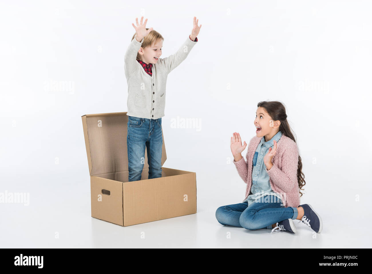 Surprised kid with boy standing in cardboard box isolated on white ...