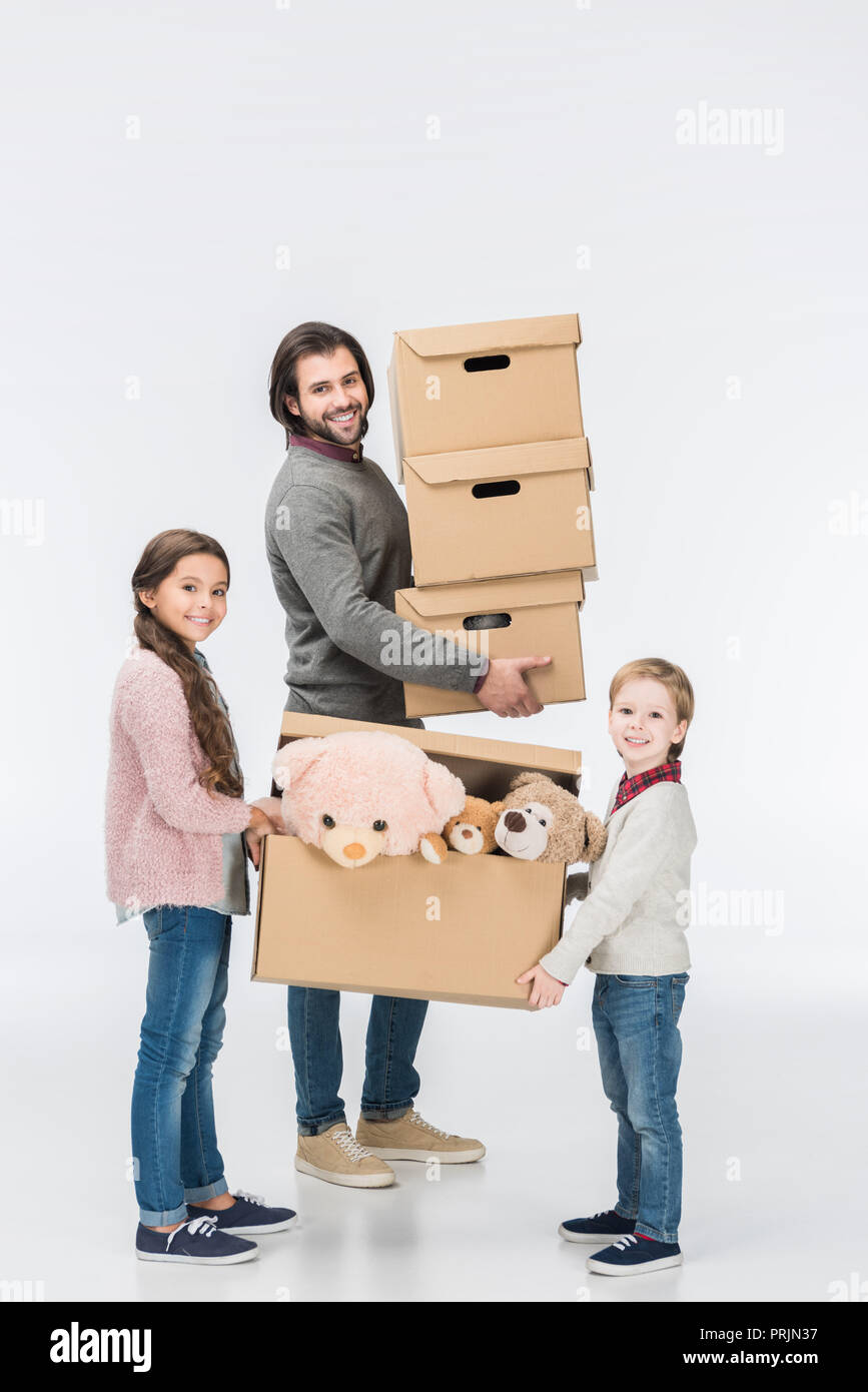 Happy children holding cardboard box with toys while father carrying ...