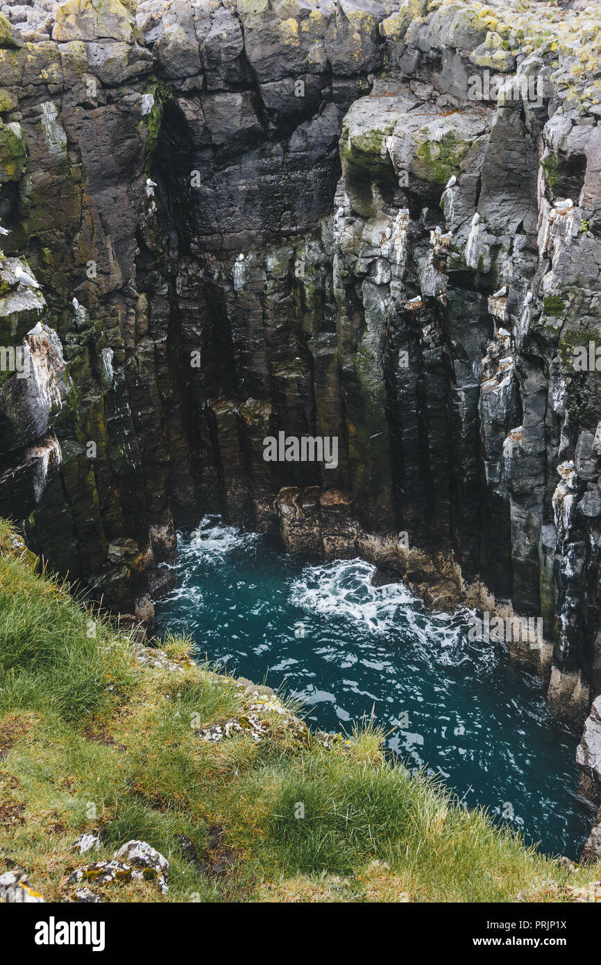 aerial view of rocky cliff and crashing blue waves in Iceland Stock ...