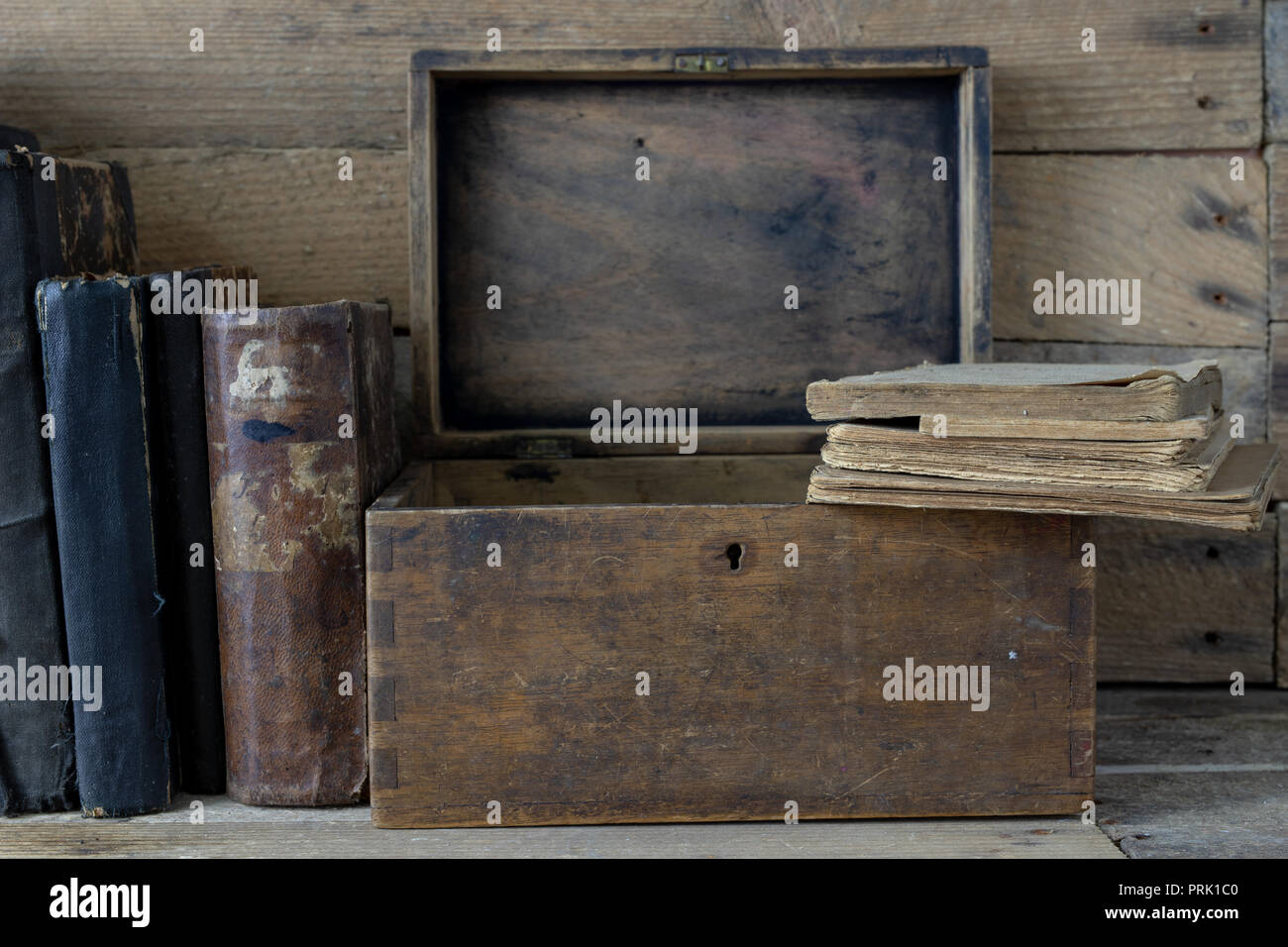 Old books and a wooden box set on a shelf. Old publishing houses set ...