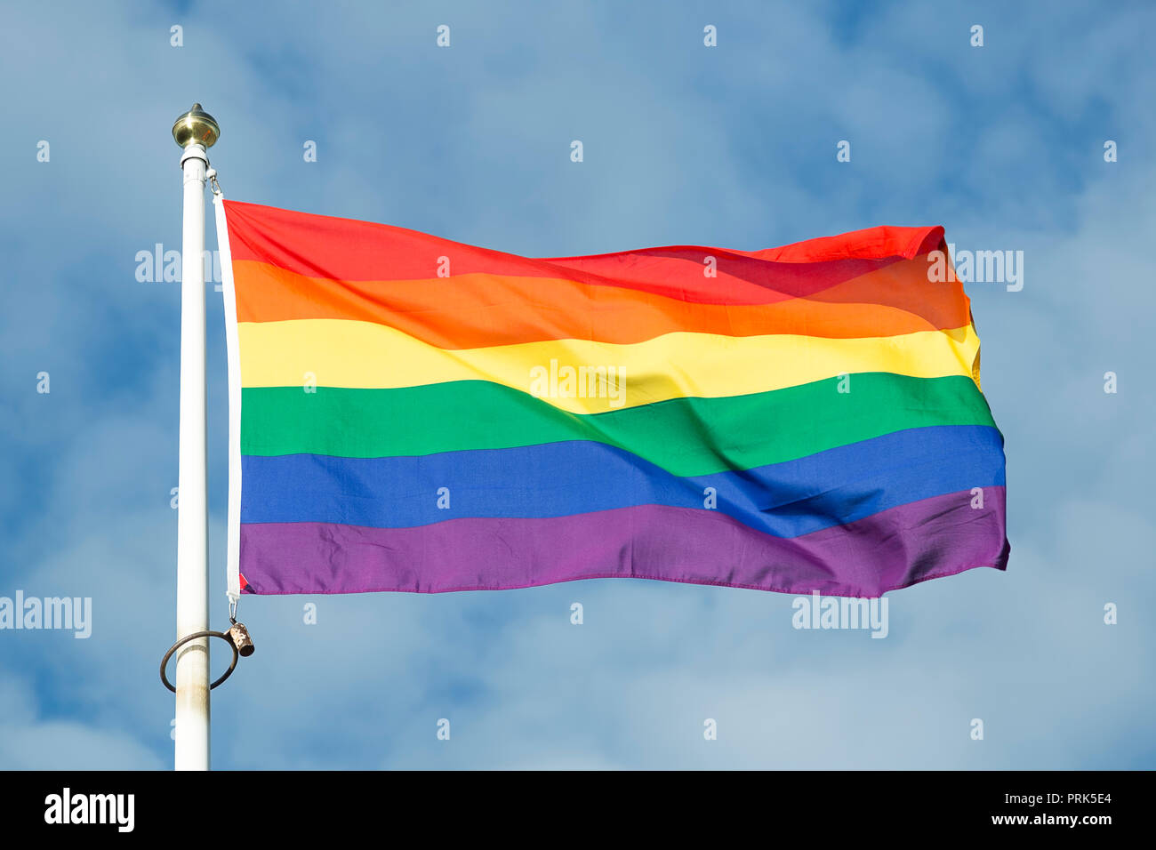 Rainbow Flag waving in the wind with a partly cloudy sky Stock Photo ...