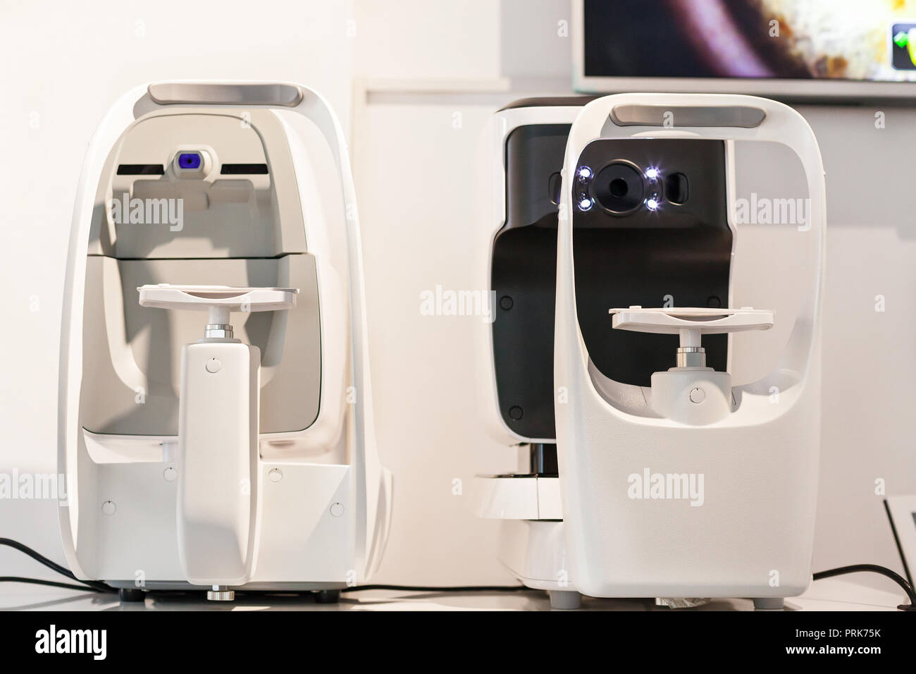 Ophthalmologist examining young man with optometric machine in optics ...