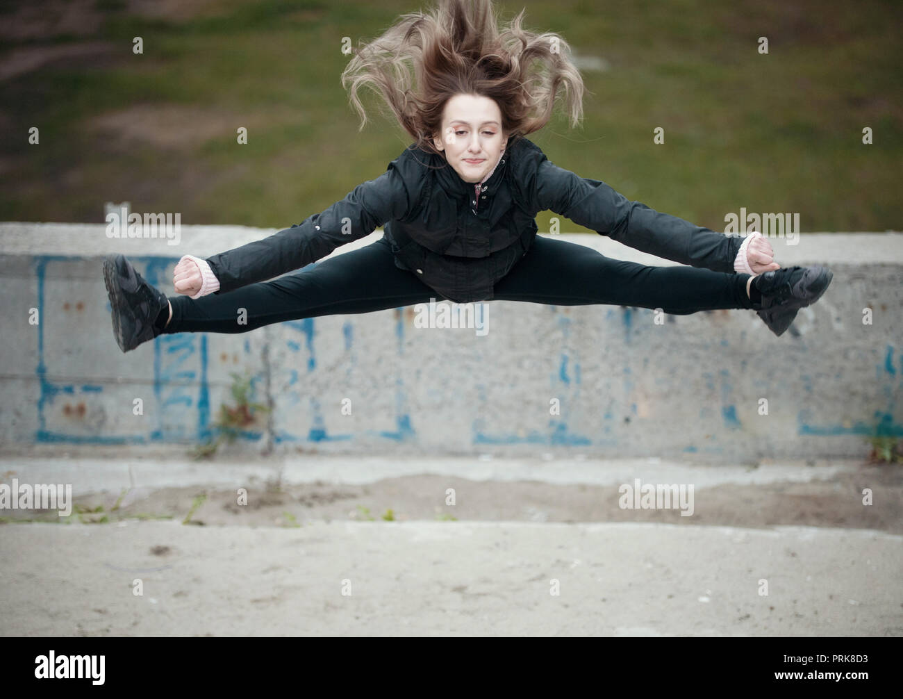 Girl jumping doing splits on the street against the background of a ...