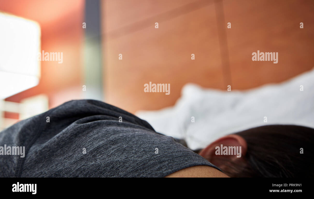 Side view of a person sleeping on a bed with shallow depth of field ...