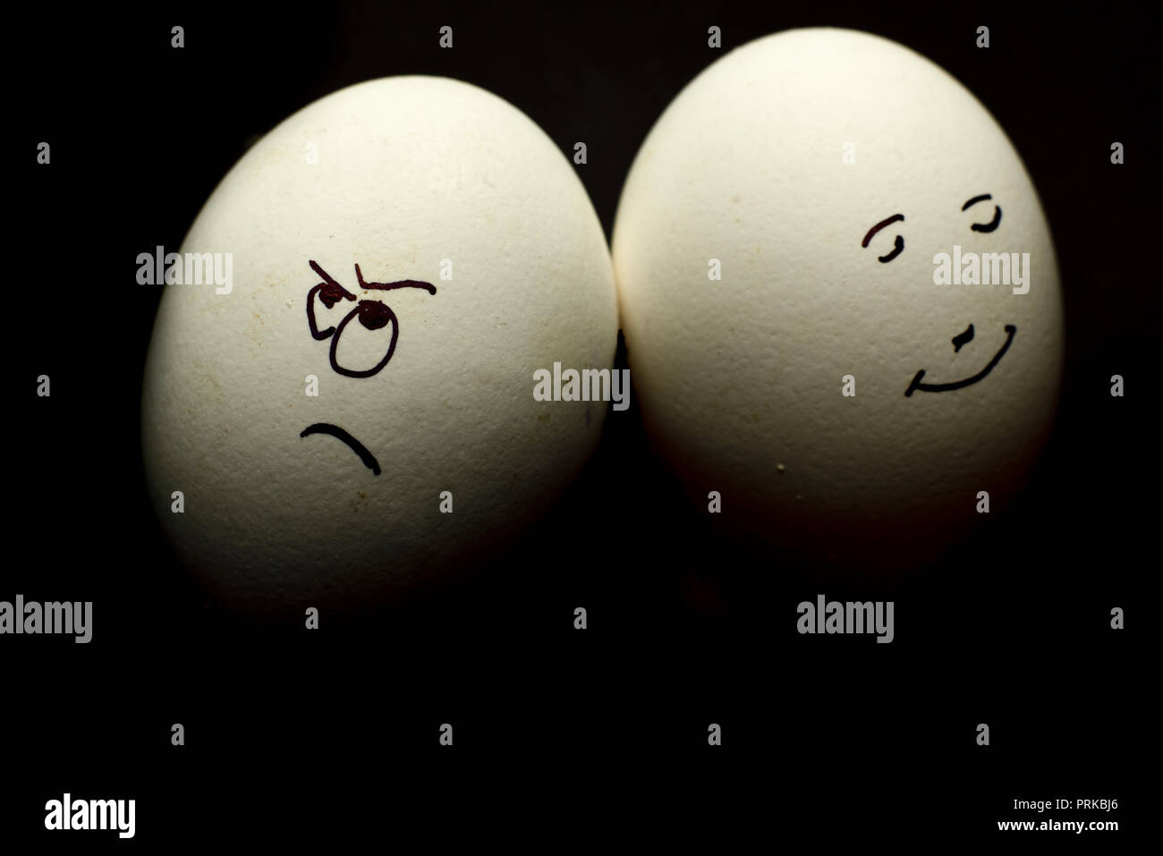 Eggs on black background. Egg represents human face isolated against ...