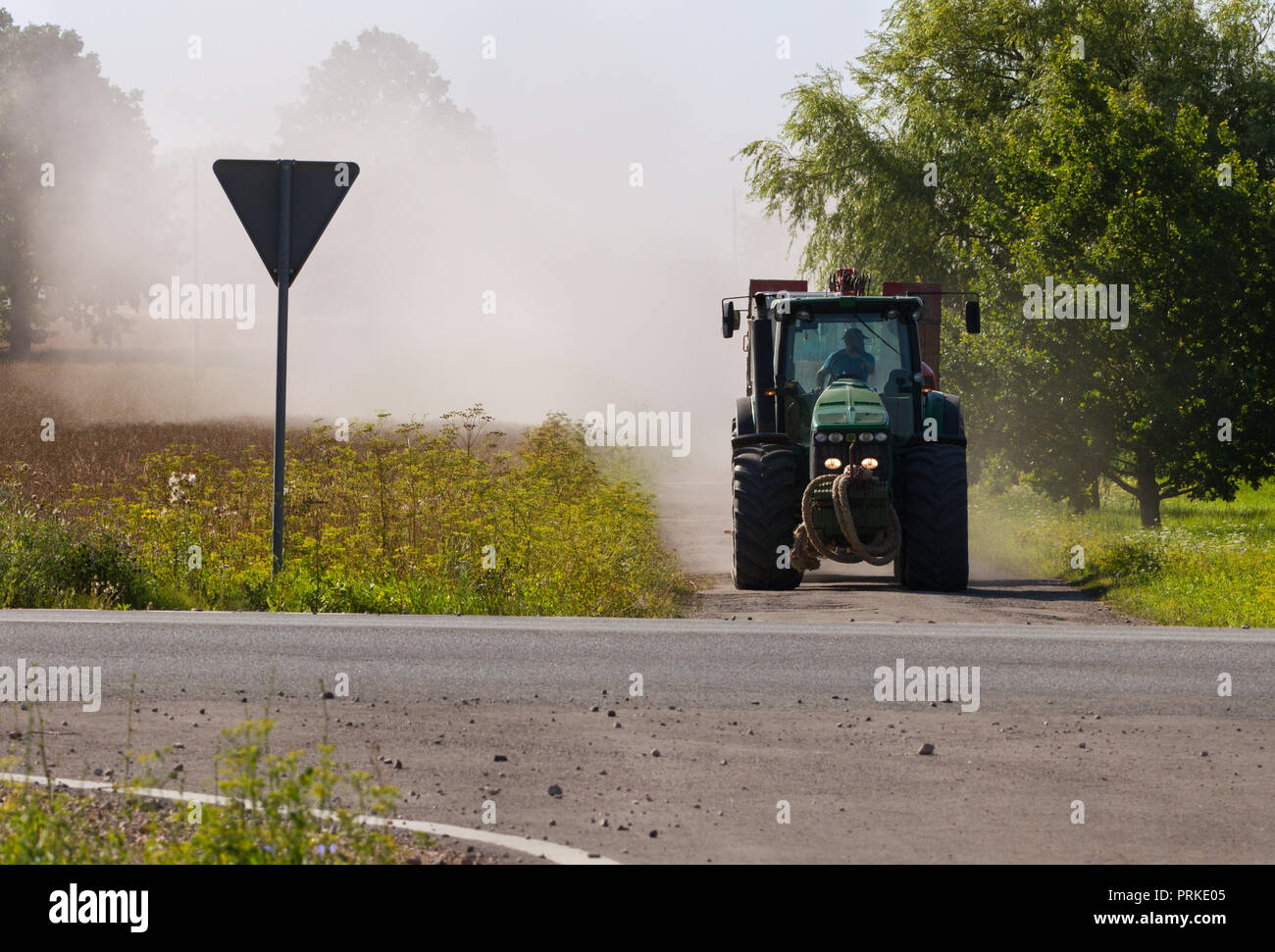 Big tractor on crossroad made cloud of dust Stock Photo - Alamy