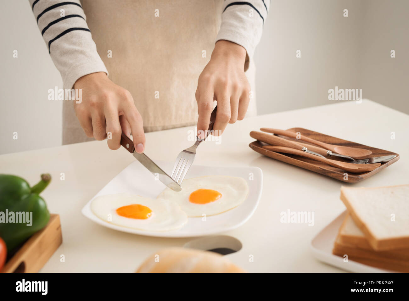 Hands of man prepare breakfast with eggs and bread Stock Photo - Alamy