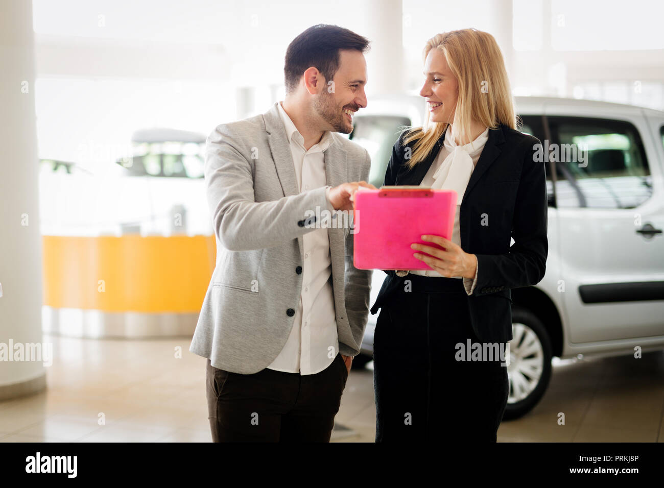 Professional salesperson selling cars at dealership to buyer Stock ...