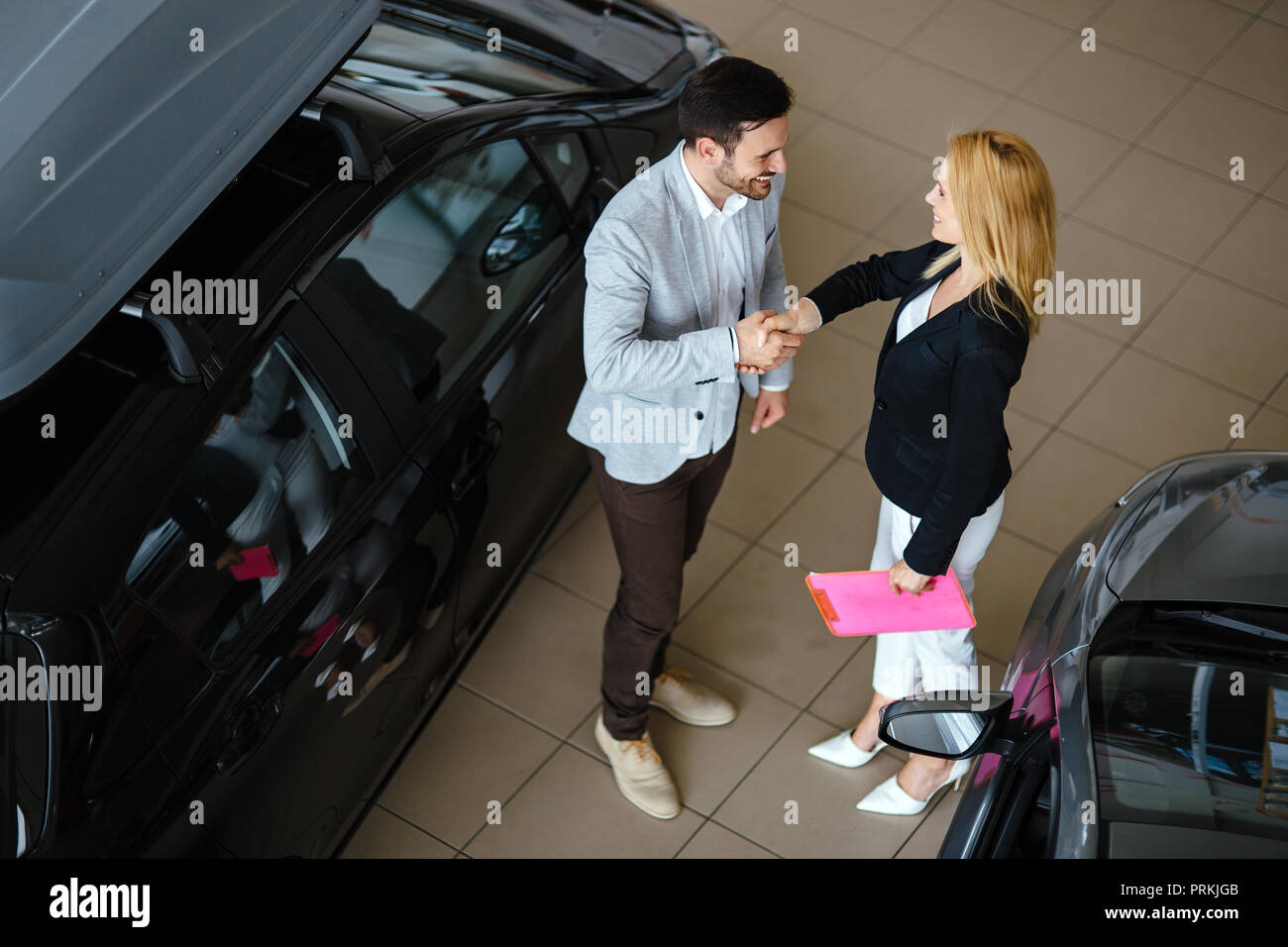 Professional salesperson during work with customer at car dealership ...