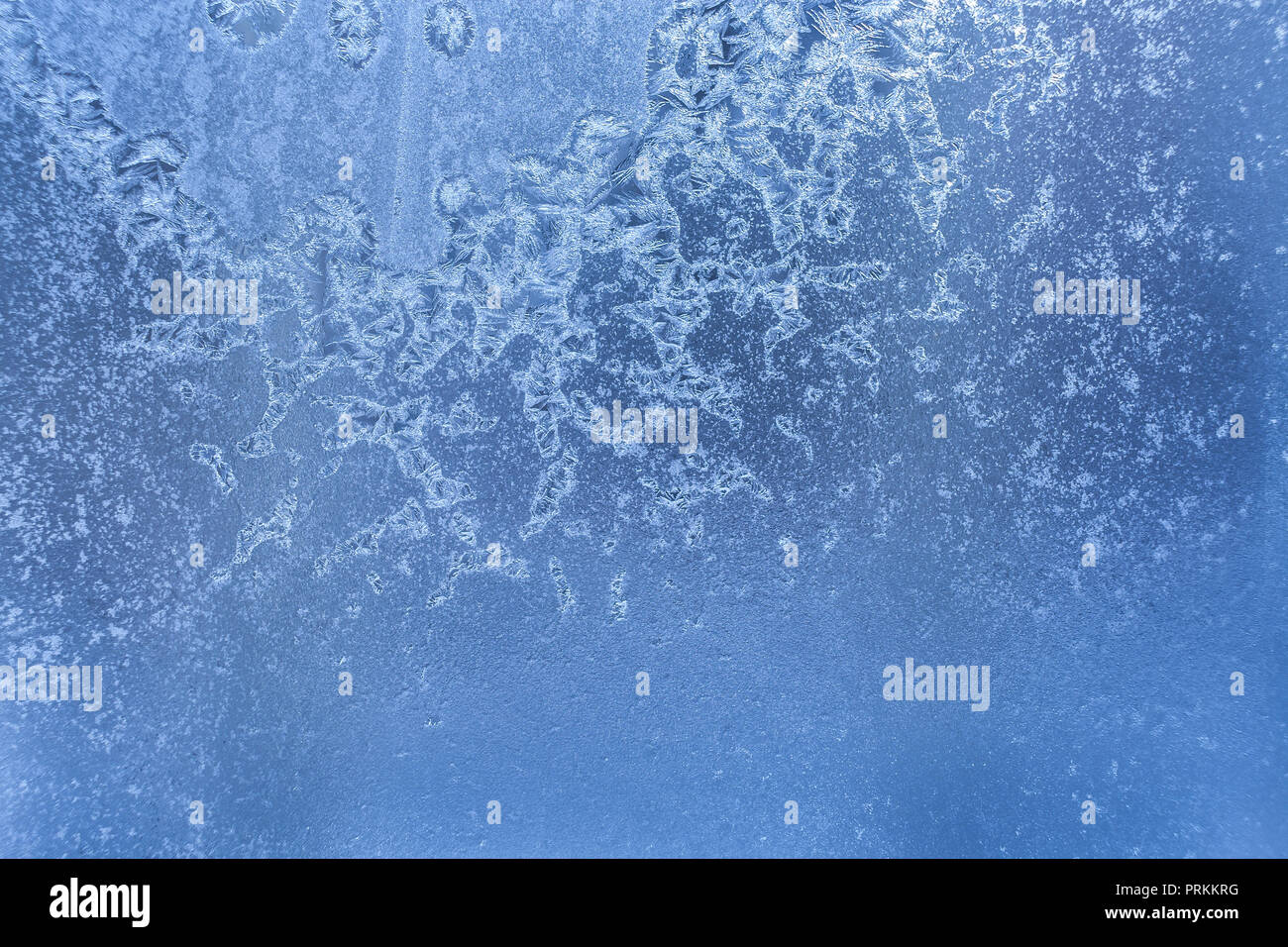 Blue frozen winter glass pane with bizarre frosty pattern of ice ...