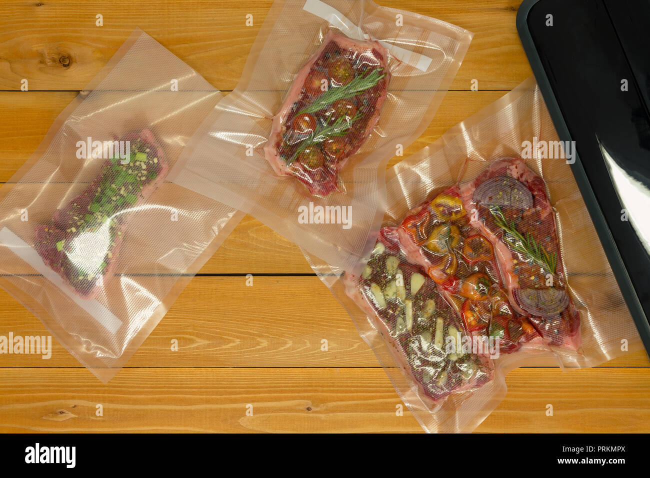 Plastic bags filled with small pieces of meat next to black vacuum ...