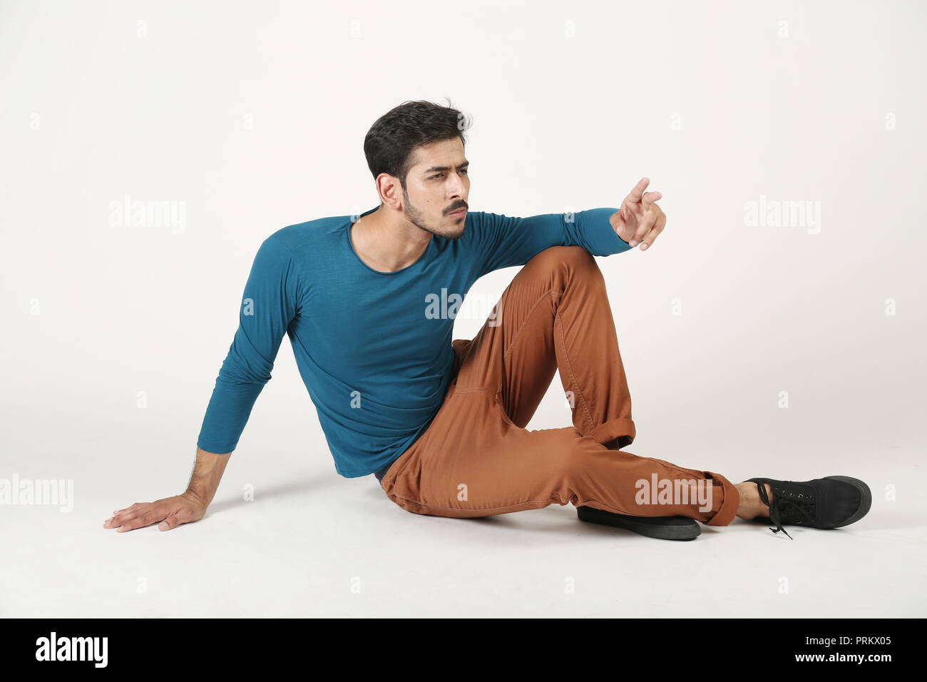 Indian boy is sitting on the floor on white background Stock Photo - Alamy