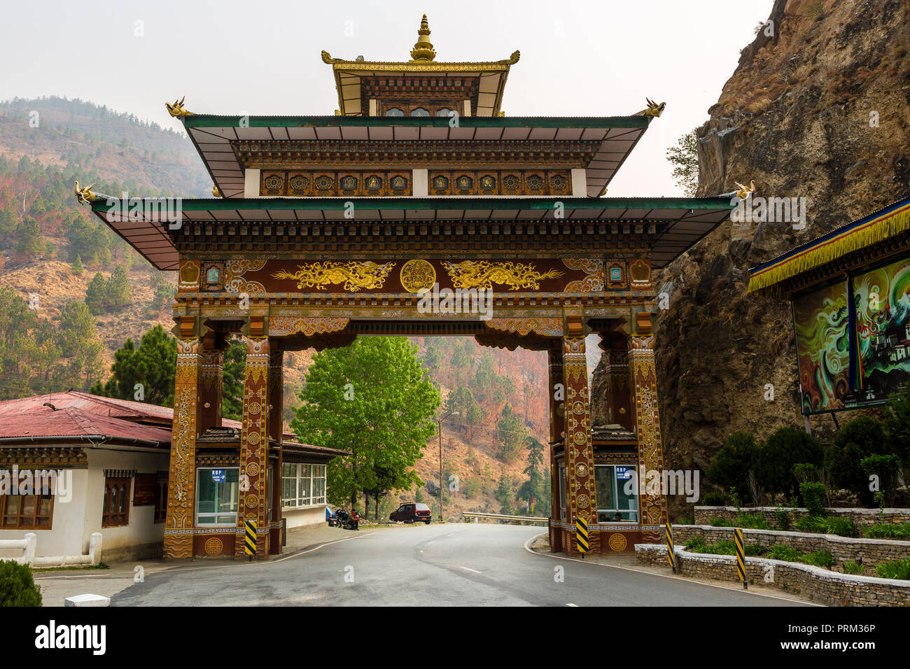 A colourful gate with ornate design on a highway road in Bhutan Stock ...