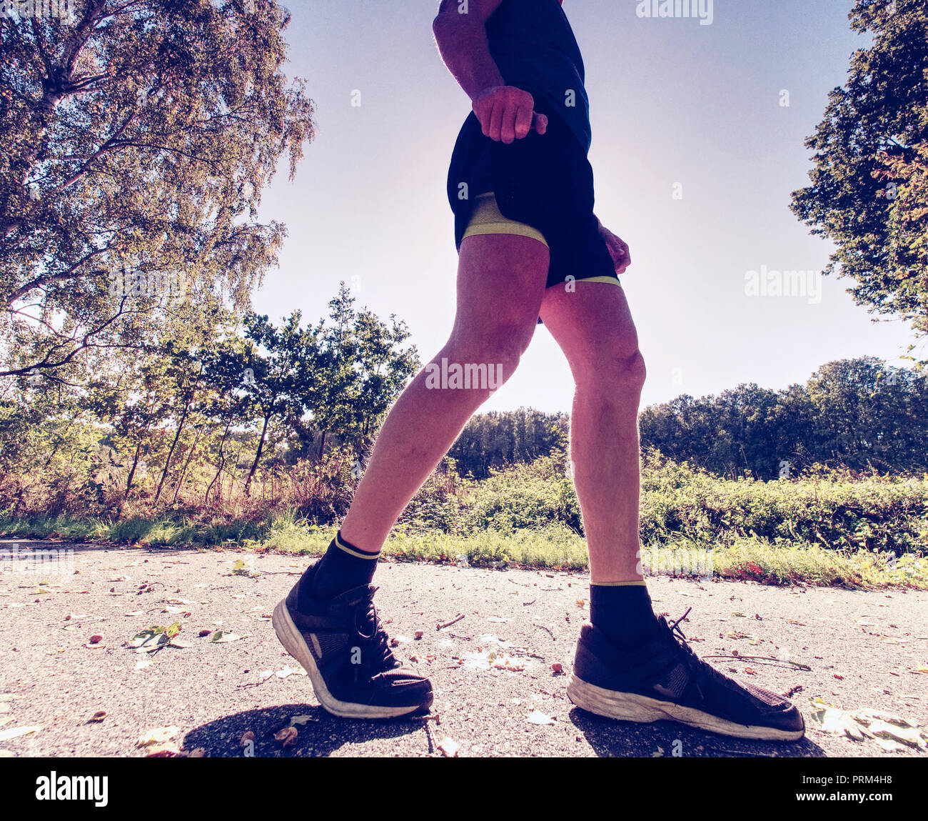 Attractive and tall runner man in slim sportswear running and training ...