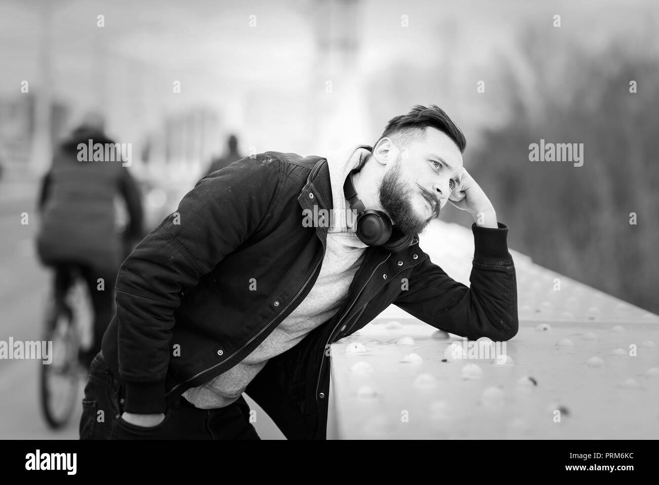 Portrait of a thinking handsome young hipster man while leaning on the ...