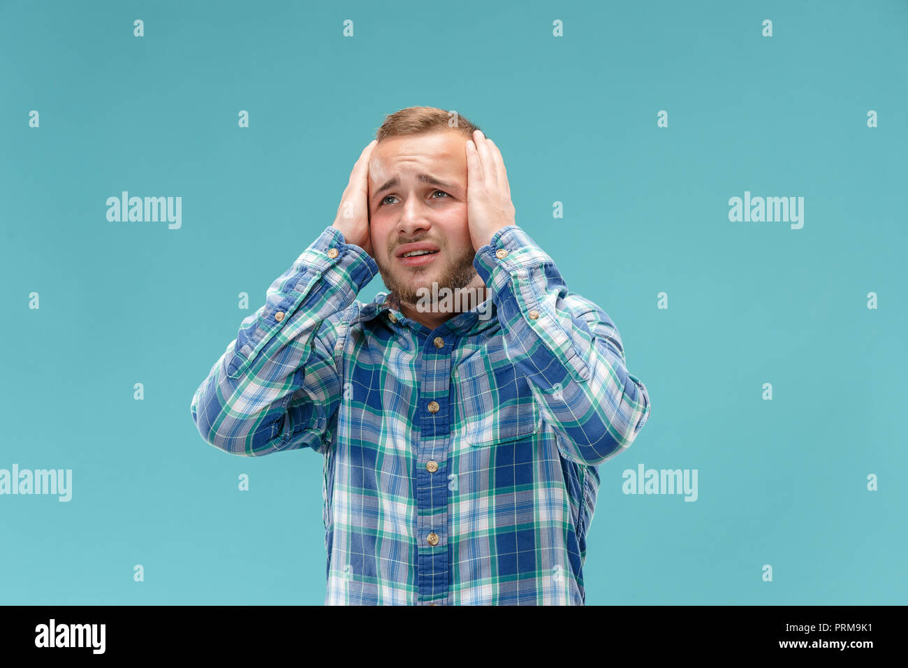Horrible, stress, shock. Male half-length portrait isolated at blue ...