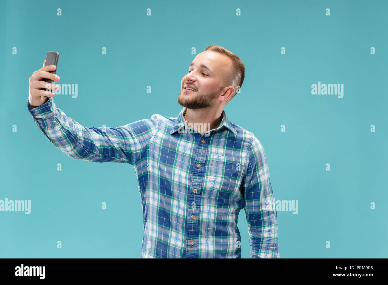 Portrait of attractive smiling young man taking a selfie with his ...
