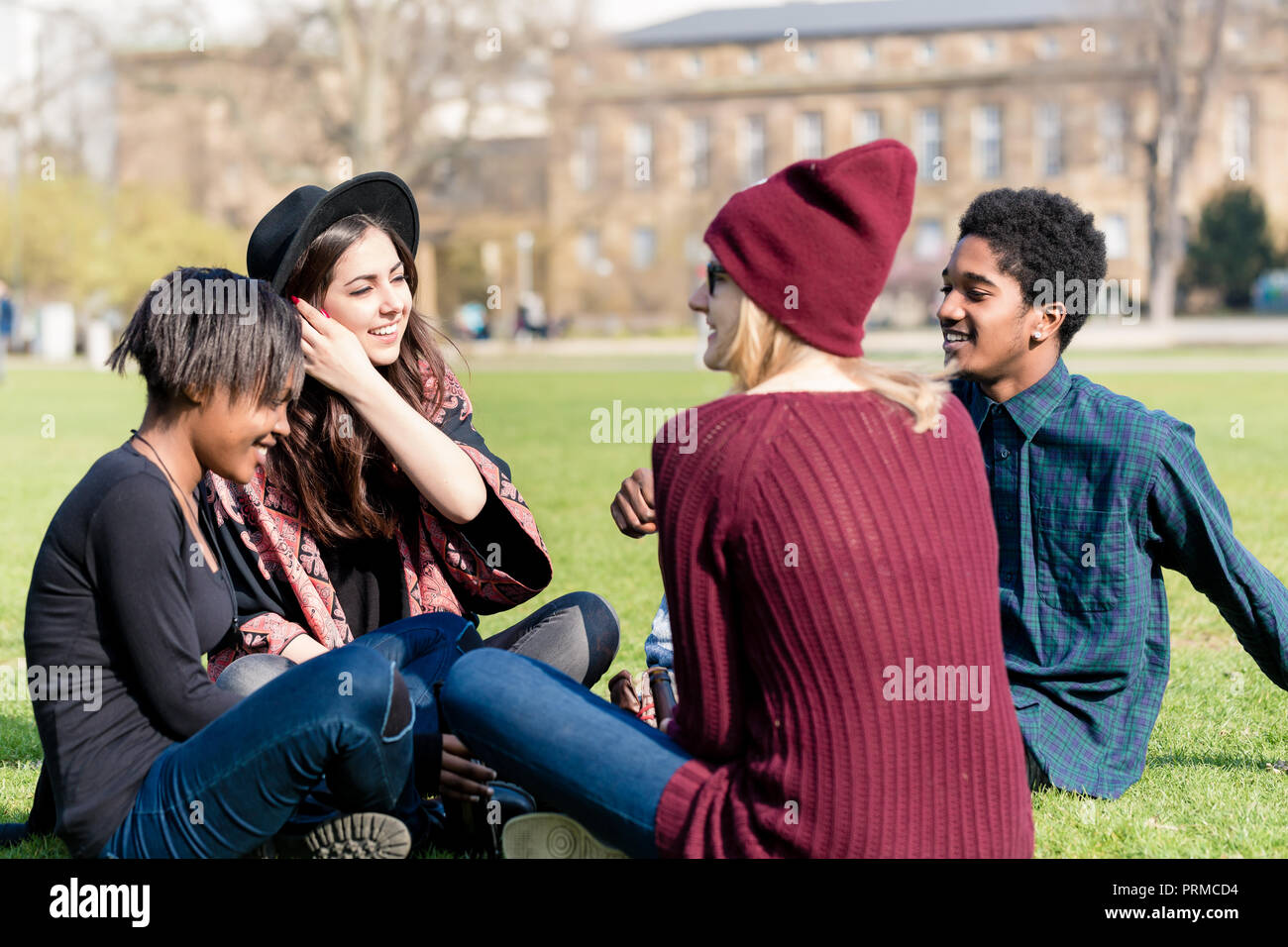 Group of happy multi ethnic friends sitting together in the park Stock ...