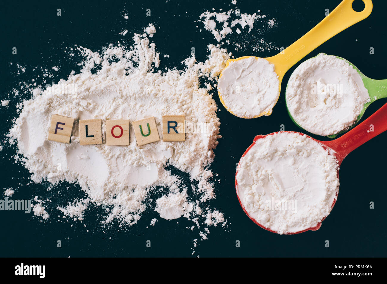 top view of a flour in a colorful measuring cup with FLOUR word on ...