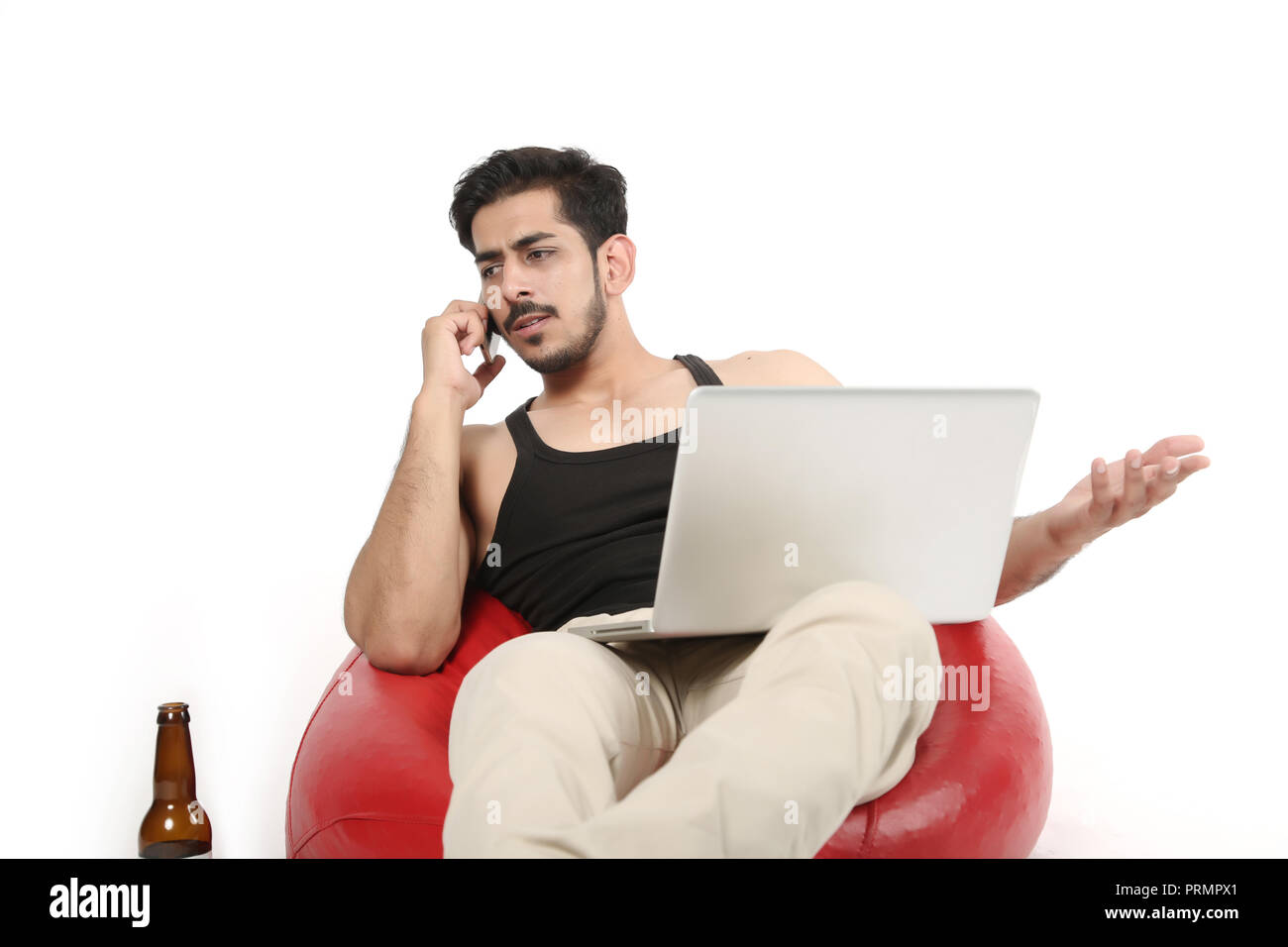 Smart young boy sitting on the red bean bag couch. Boy talking on the ...