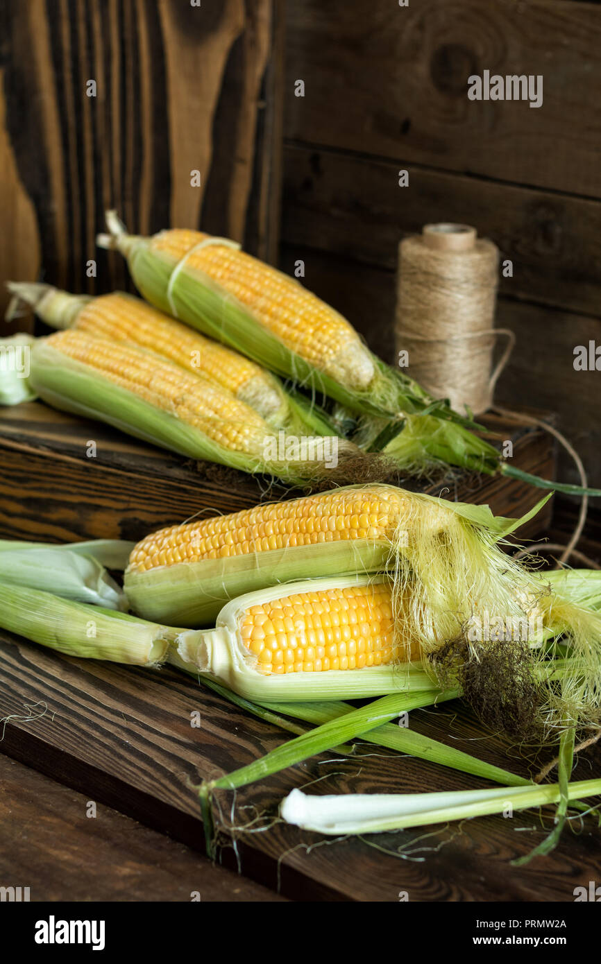 Fresh sweet corn on cobs on rustic wooden table, close up. Toned ...
