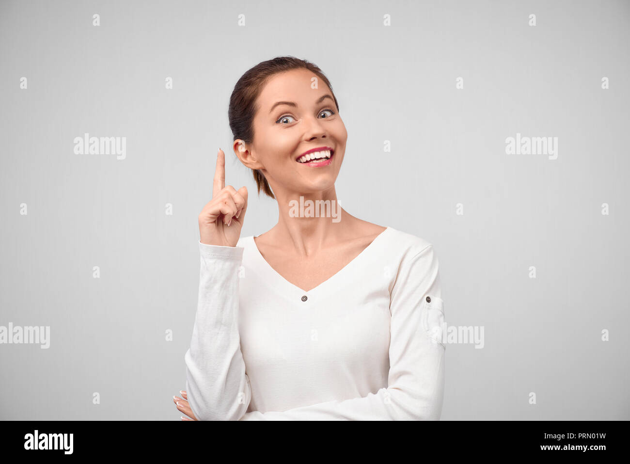 Portrait of clever attractive european female raising index finger in ...