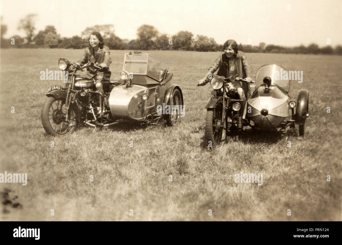 Two women riding their veteran motorcycle combinations in a field. 1927 ...