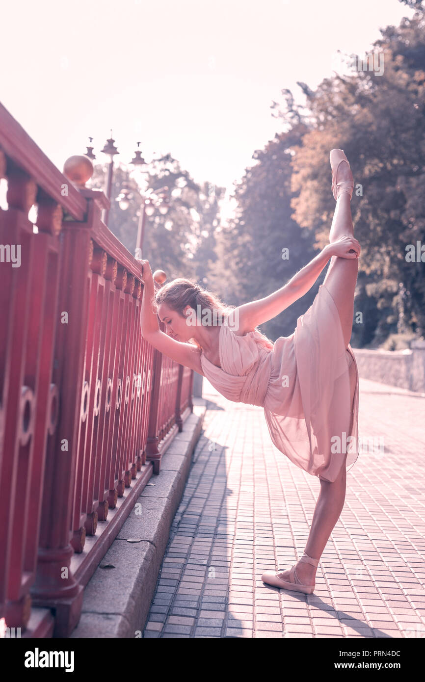 Pleasant flexible young woman touching her leg Stock Photo - Alamy