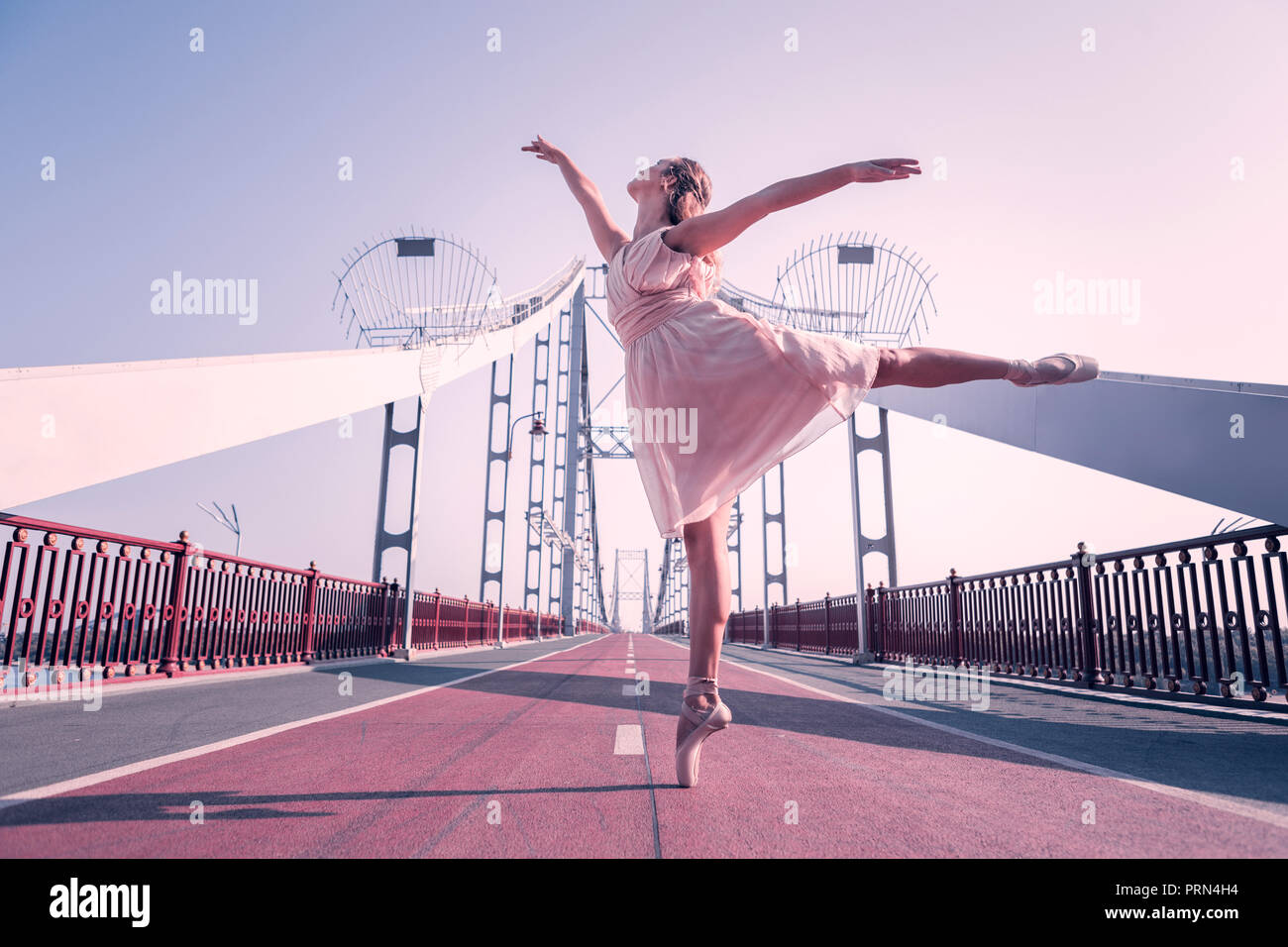 Positive attractive woman dancing alone on the bridge Stock Photo - Alamy
