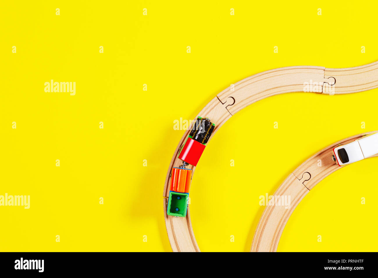 Toy trains and wooden rails on yellow and blue color background Stock ...