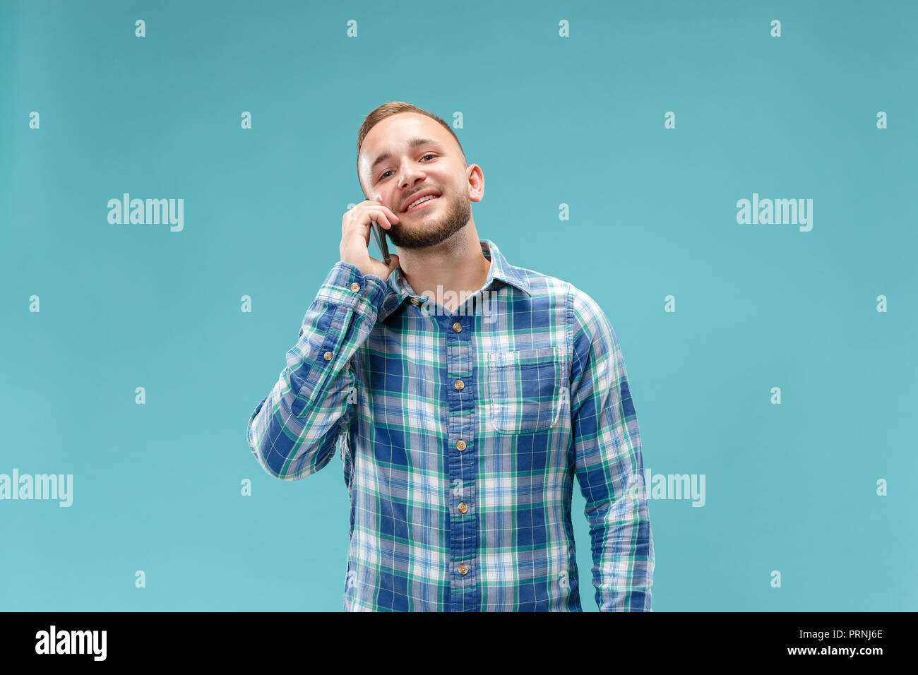 Young handsome man talking over phone and looking away. Young ...
