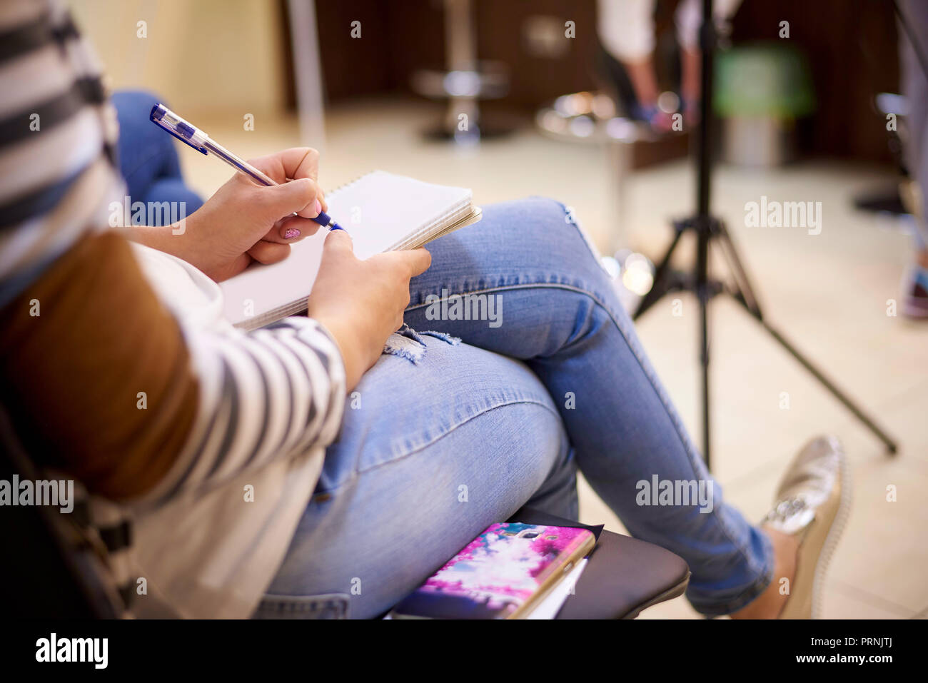 The girl takes notes in a notebook sitting on a chair close-up Stock ...