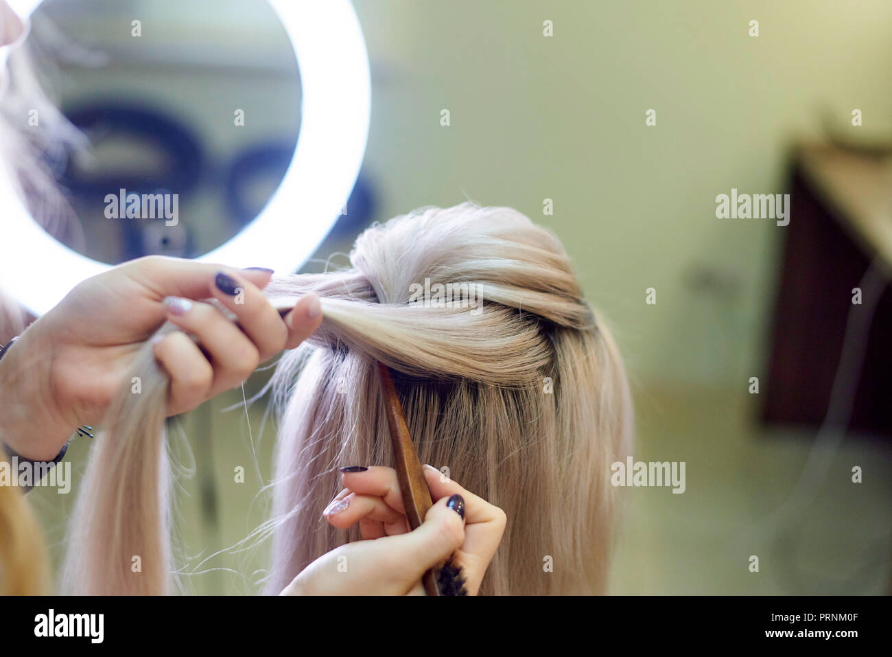 Hairdressing services.Сreating an evening hairstyle. Hair styling ...