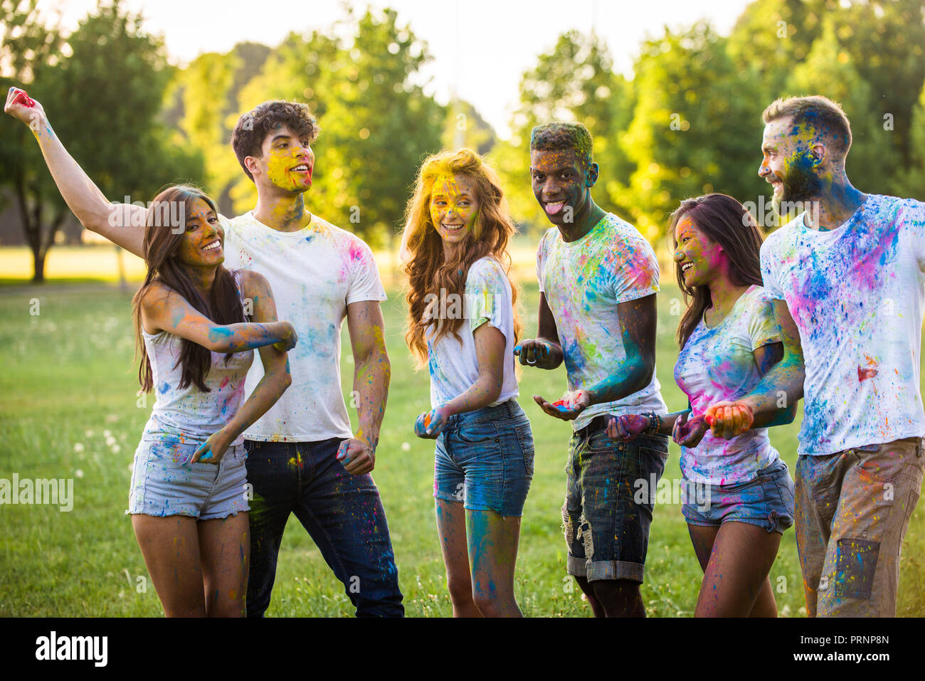 Group of happy friends playing with holi colors in a park - Young ...