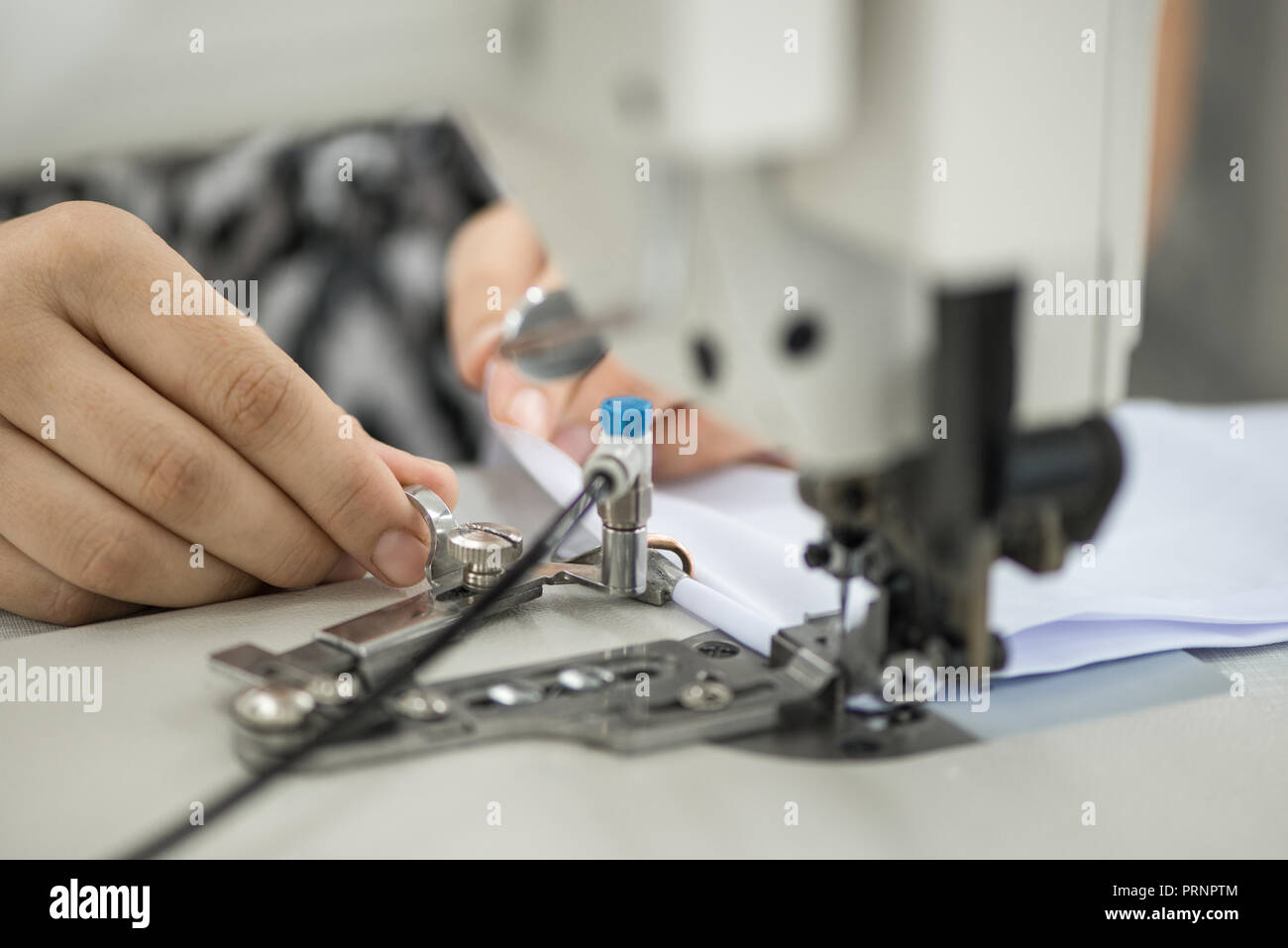 seamstress on a sewing machine makes a shirt in the sewing workshop ...