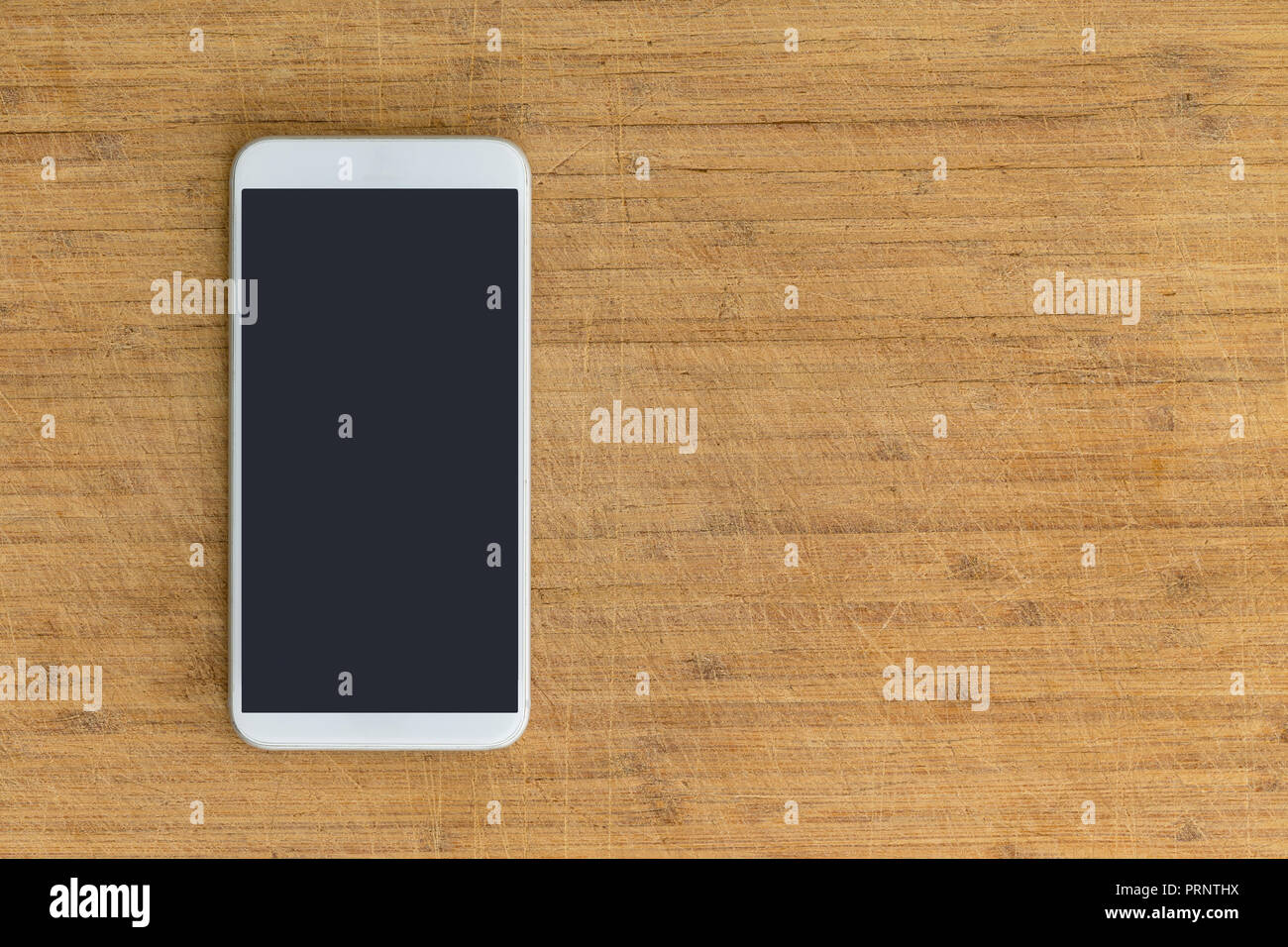 Single rectangular isolated white smart phone with power off sitting on ...