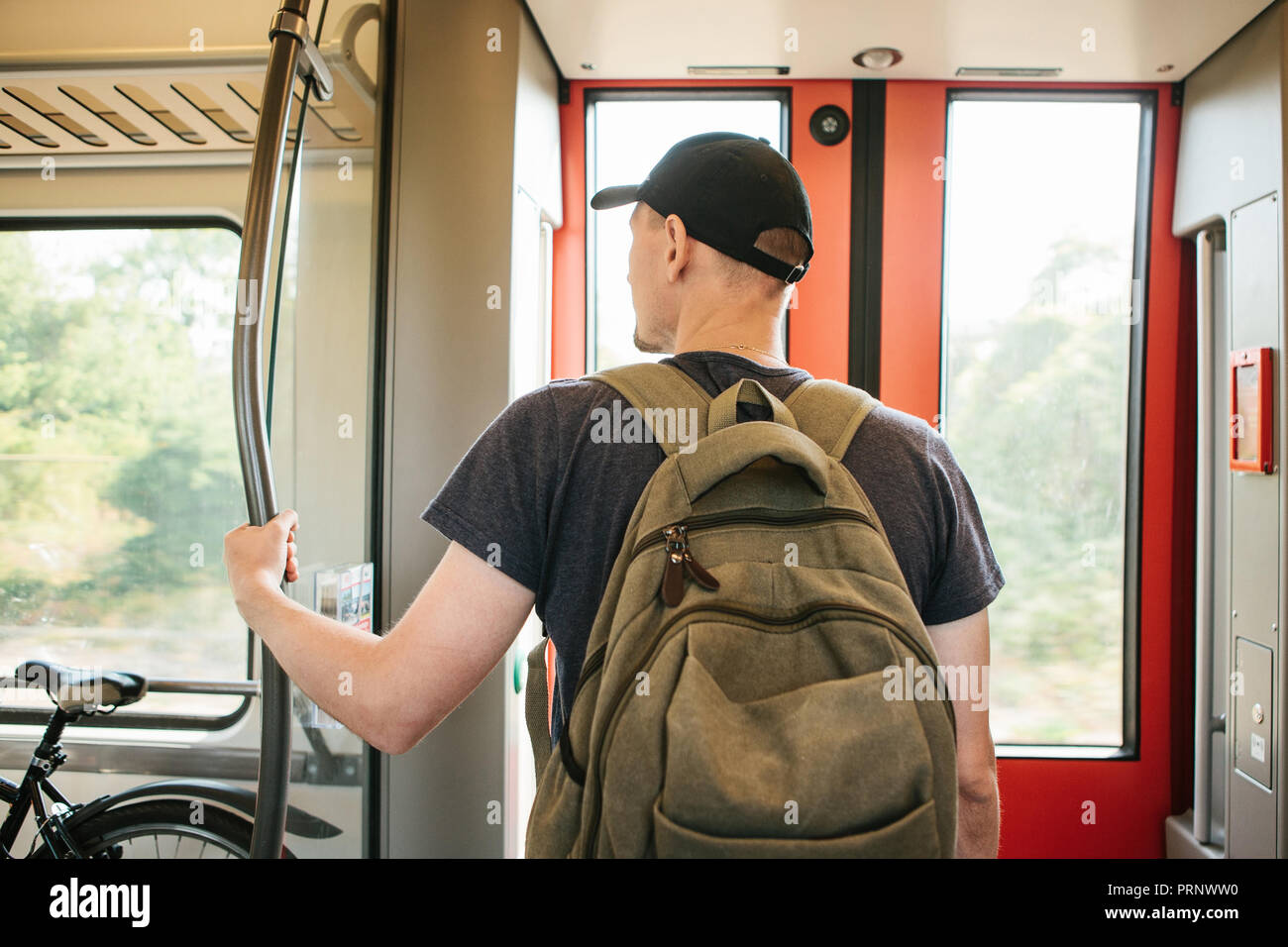 Tourist man or student with a backpack waiting for the train to stop to ...
