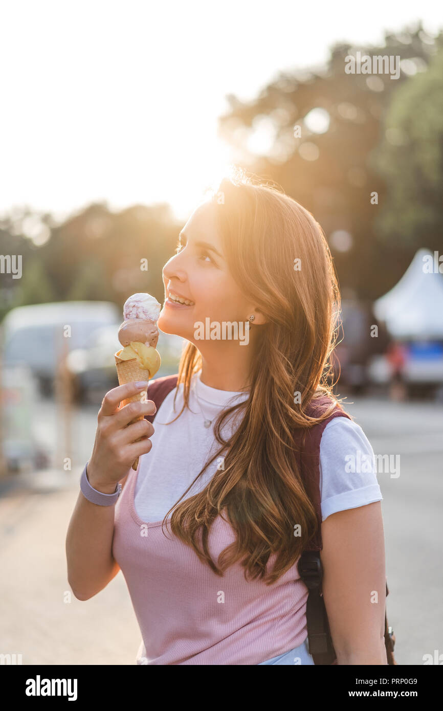 side view of smiling young woman eating ice cream Stock Photo - Alamy