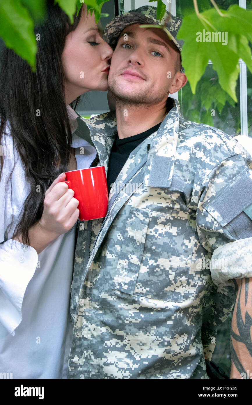 Happy wife kissing soldier husband as her returns home from war Stock ...