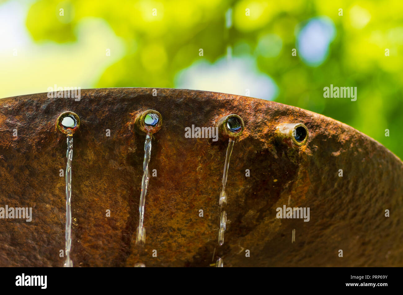 Small jets of water from pipes of a rusty fountain Stock Photo - Alamy