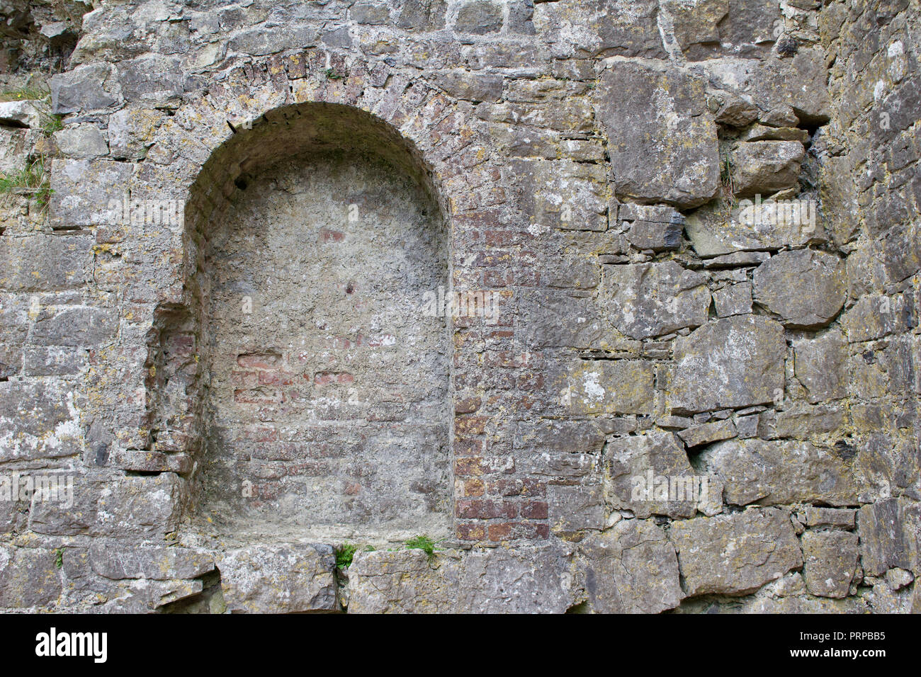 View of a bricked-in arched stone window in a medieval castle ruin in ...