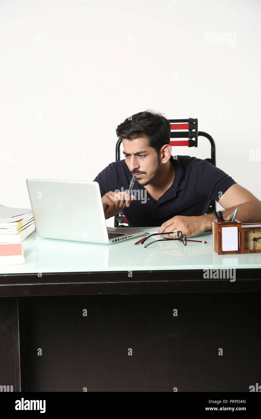 Boy is some thinking and looking laptop. Isolated on white background ...