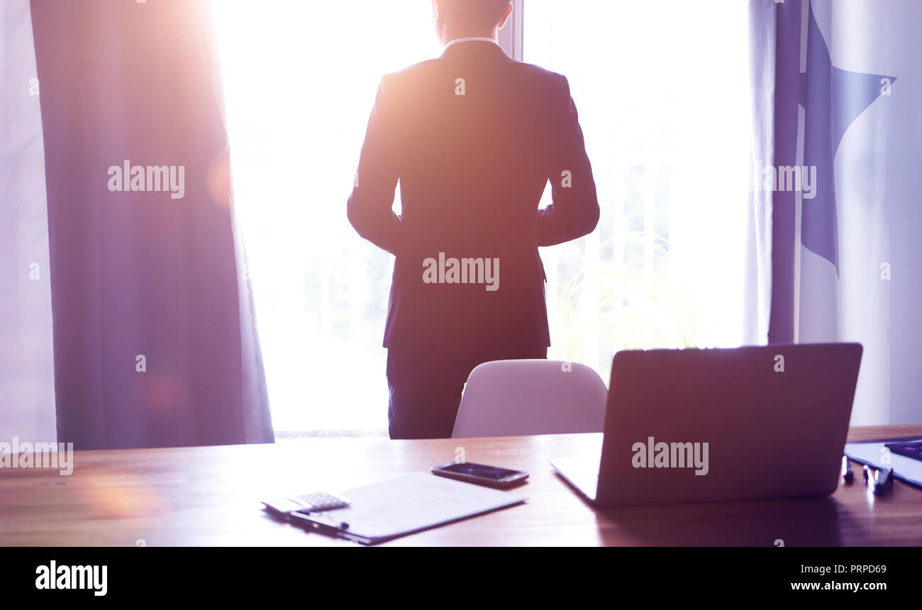 Rear angle view of businessman thinking the future vision at office ...