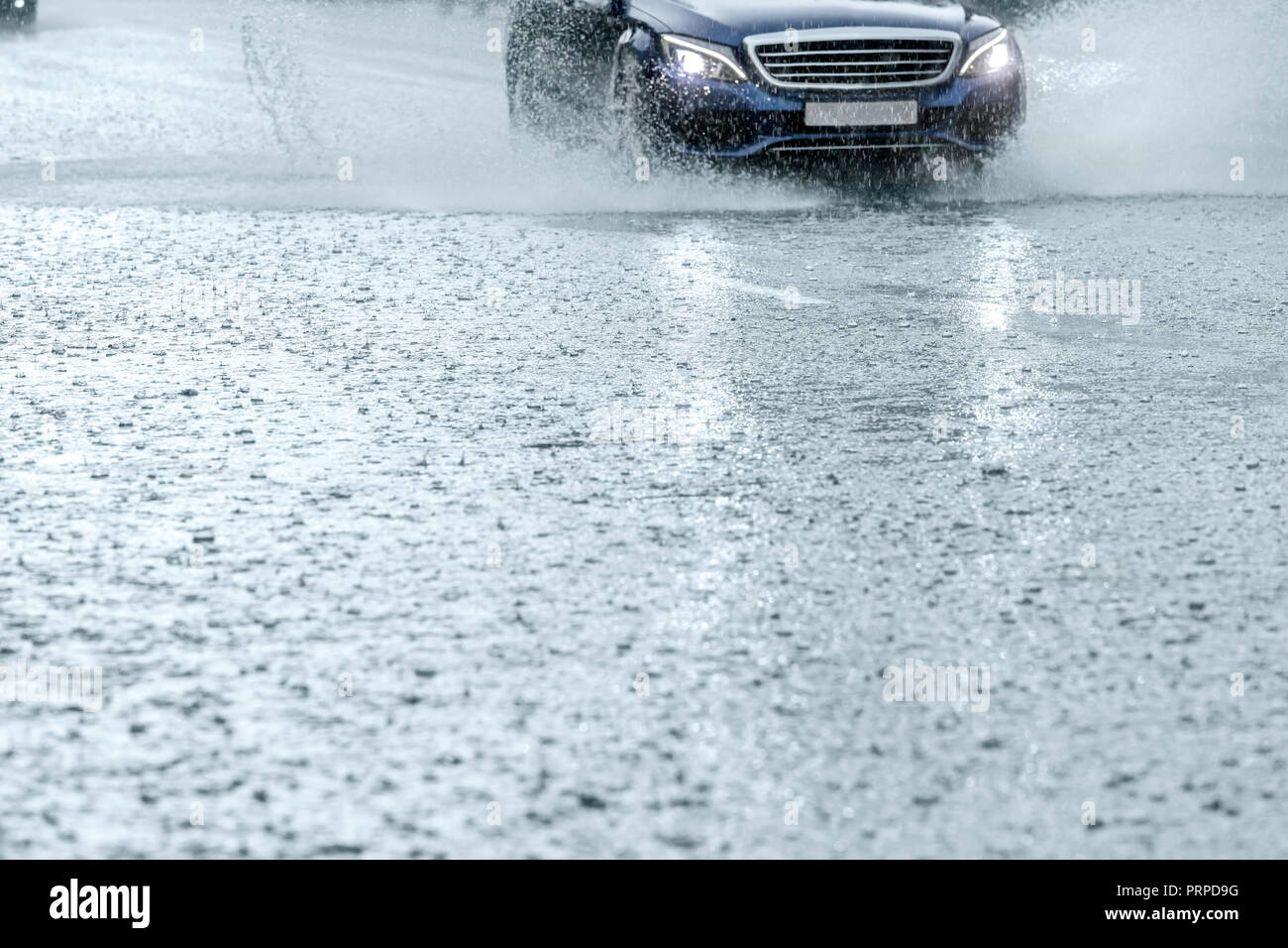 car in motion during heavy rain. asphalt city road covered with rain ...