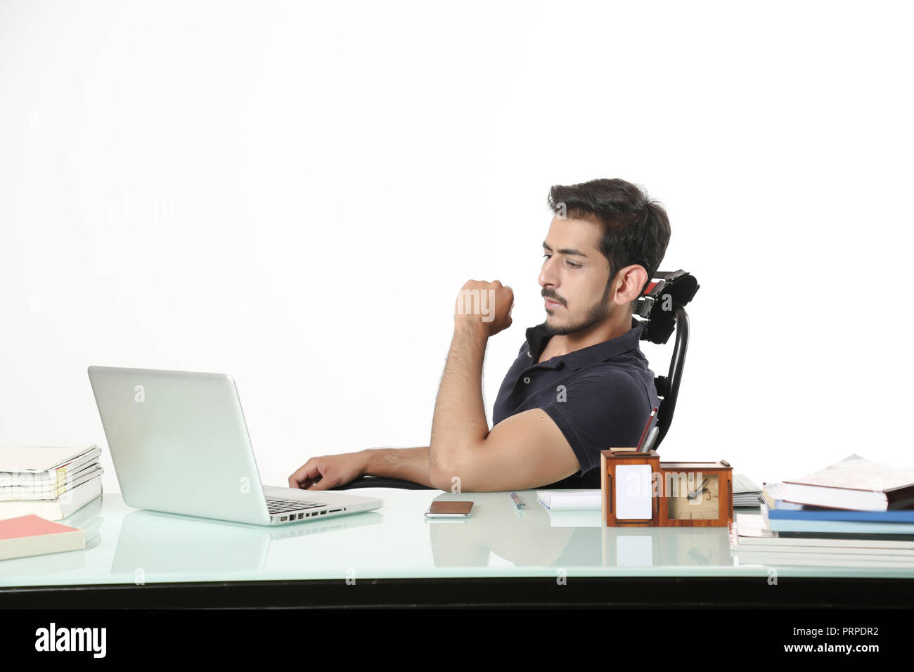 Young boy is looking laptop sitting on the chair in the office ...