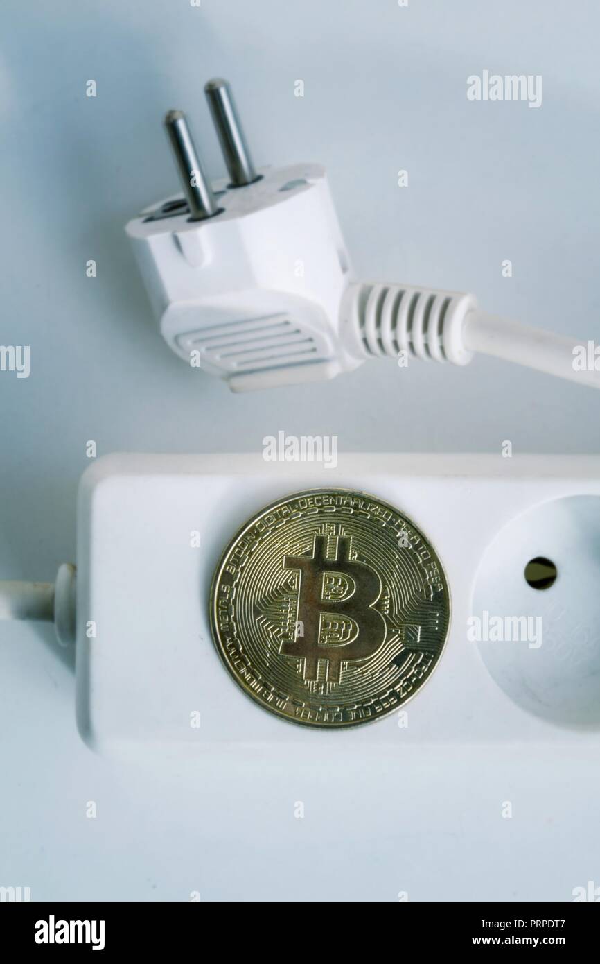 Bitcoin coin lying on power strip extension cord with two empty sockets ...