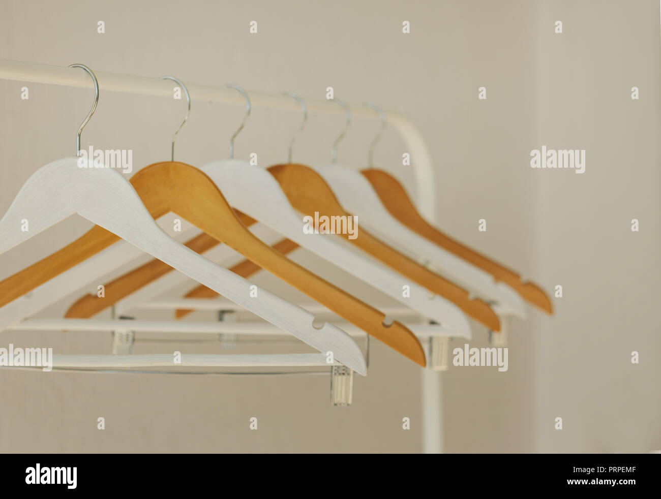 White row of hangers on the rack. Selective focus Stock Photo - Alamy