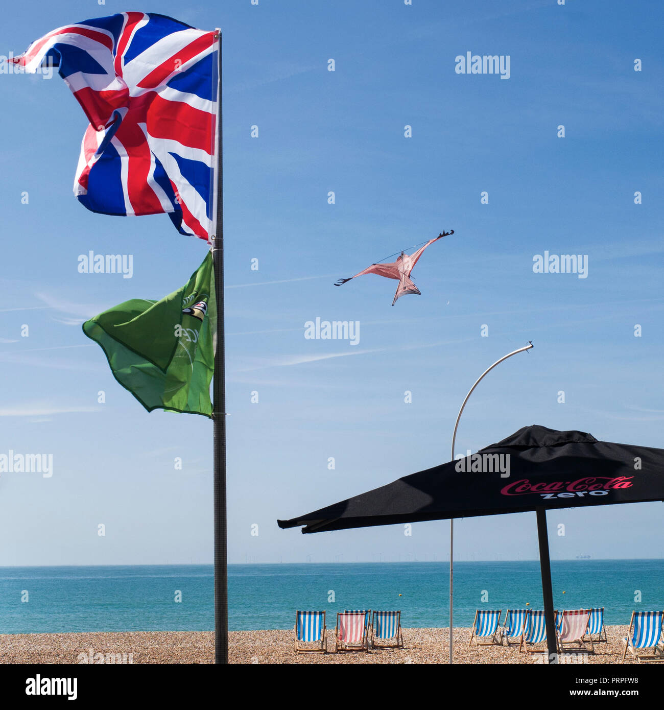 union flag flying in wind over Brighton beach and deck chairs Stock ...